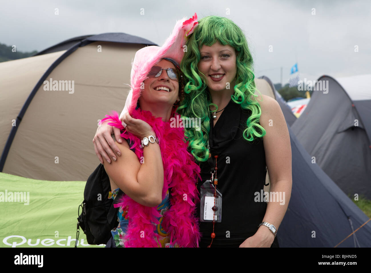 Two girls with vibrant greenhair and pink boa in the campsite at ...