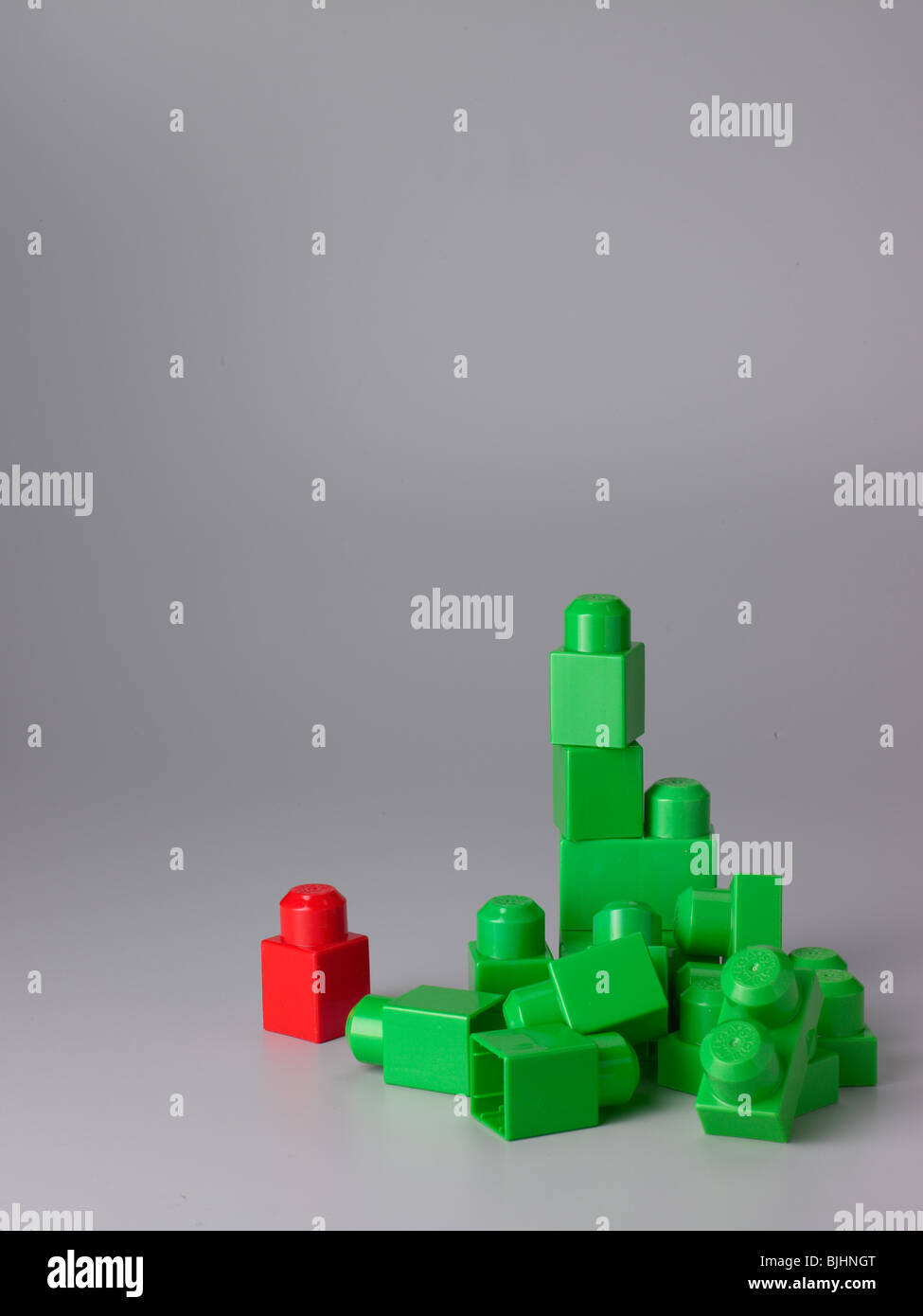 Green and red toy building blocks on grey showing formation and ...
