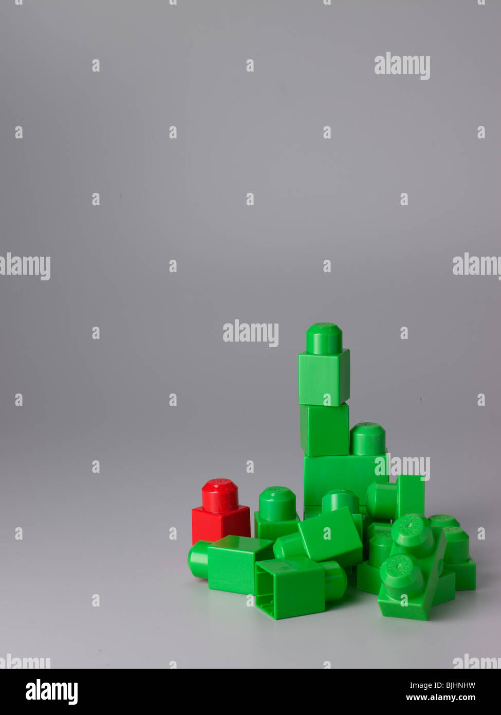 Green and red toy building blocks on grey showing formation and ...