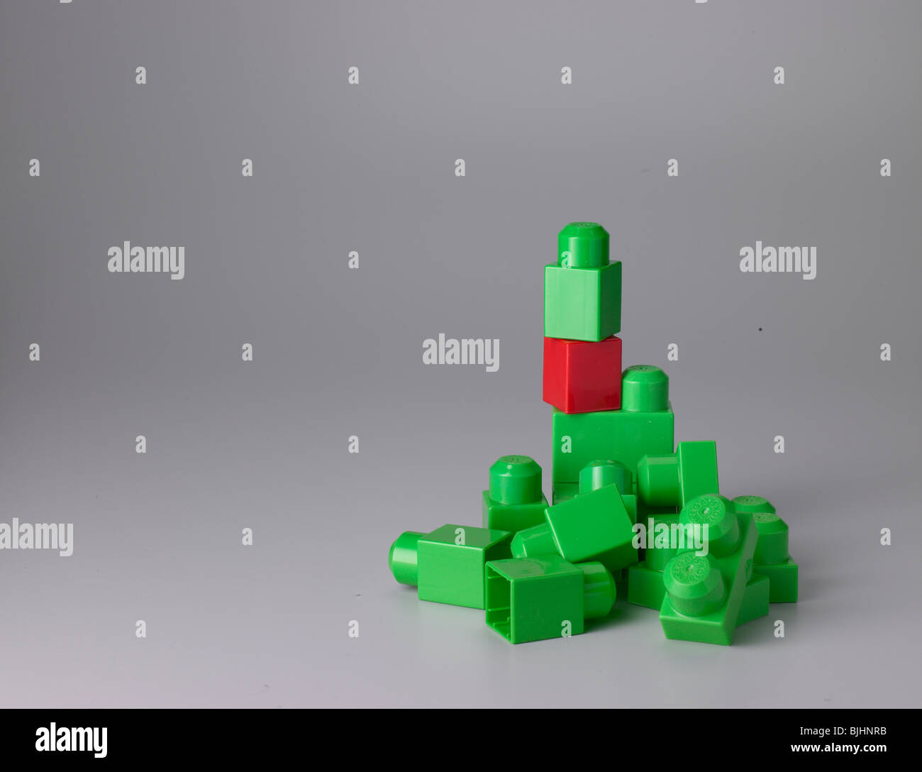 Green and red toy building blocks on grey showing formation and ...