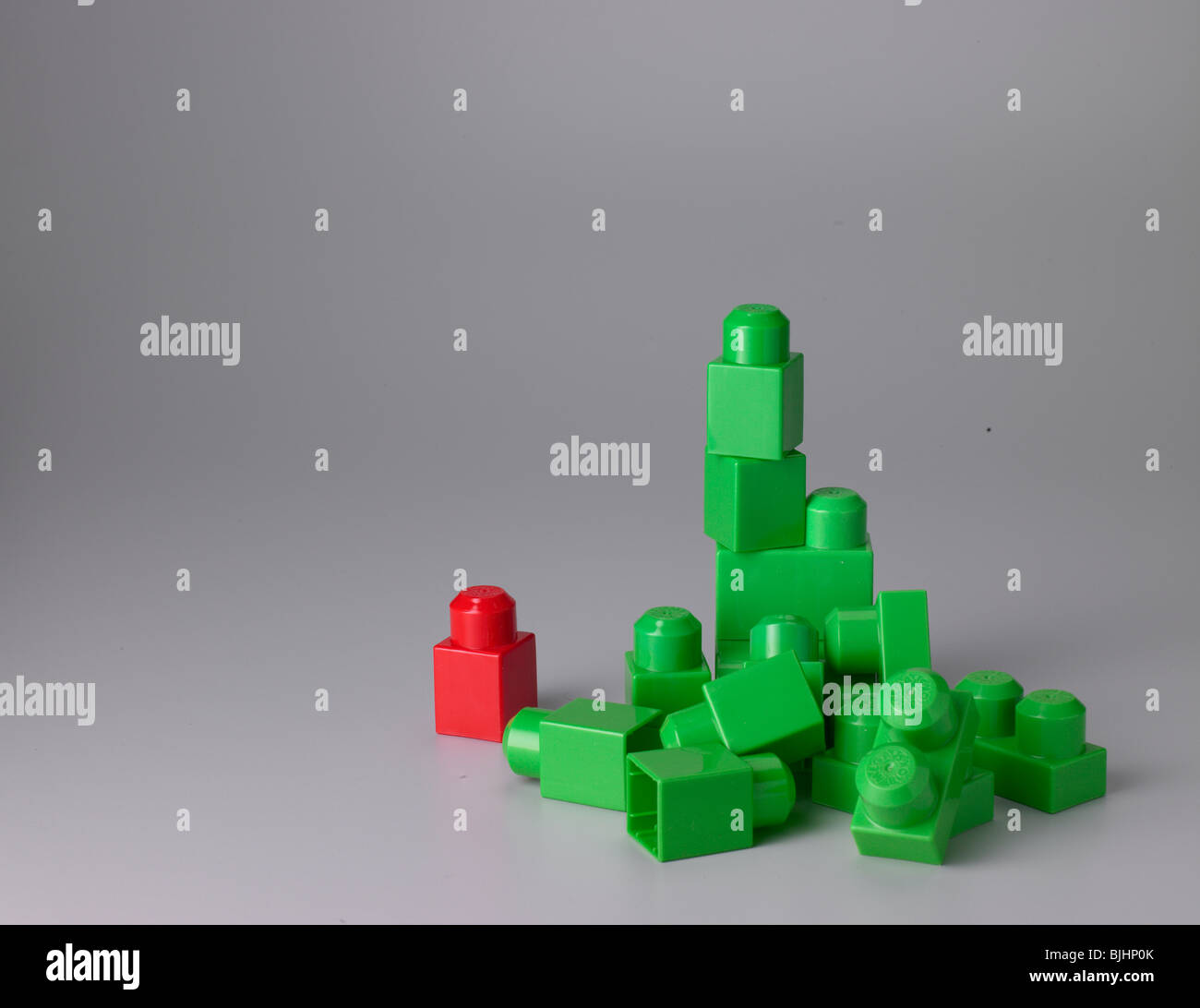 Green and red toy building blocks on grey showing formation and ...