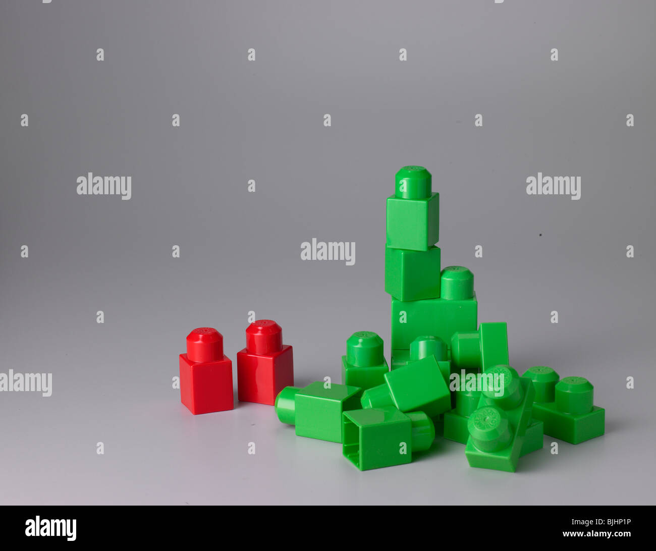 Green and red toy building blocks on grey showing formation and ...
