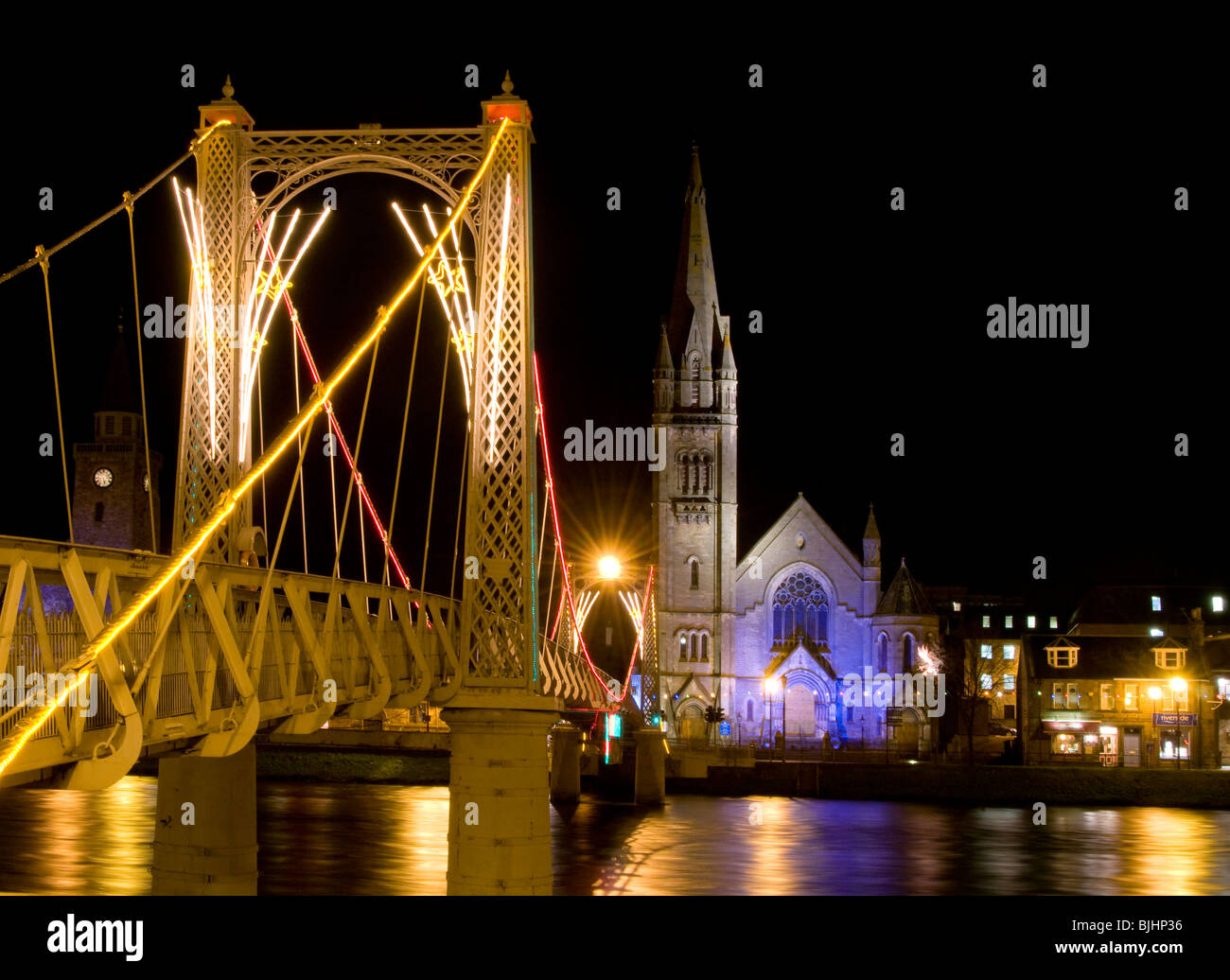 Illuminated Inverness suspension bridge by night with River Ness in ...