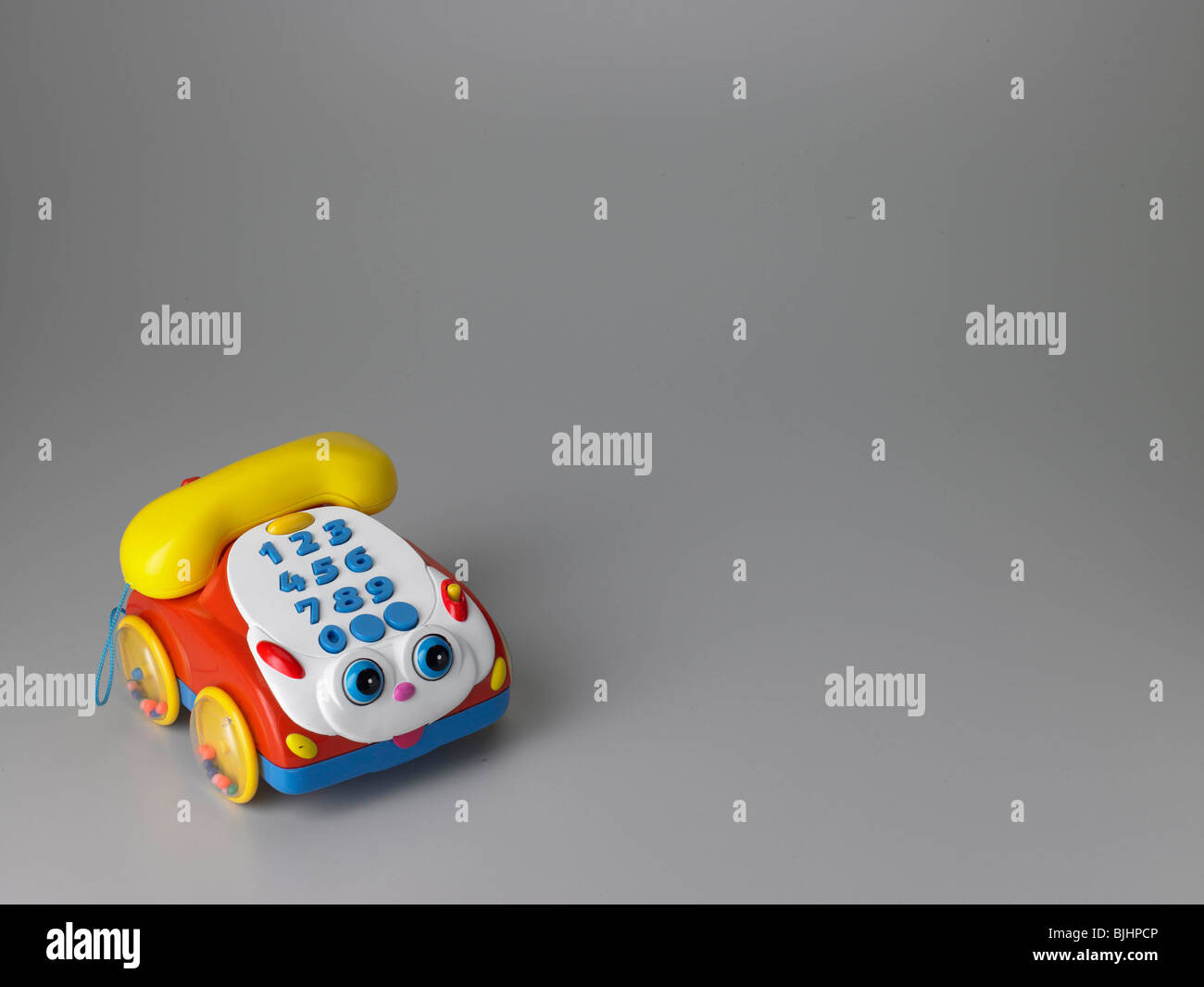 Fun toy telephone on grey Stock Photo - Alamy