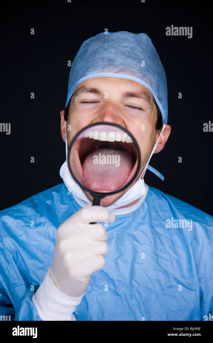 doctor holding up a magnifying glass to his mouth Stock Photo - Alamy