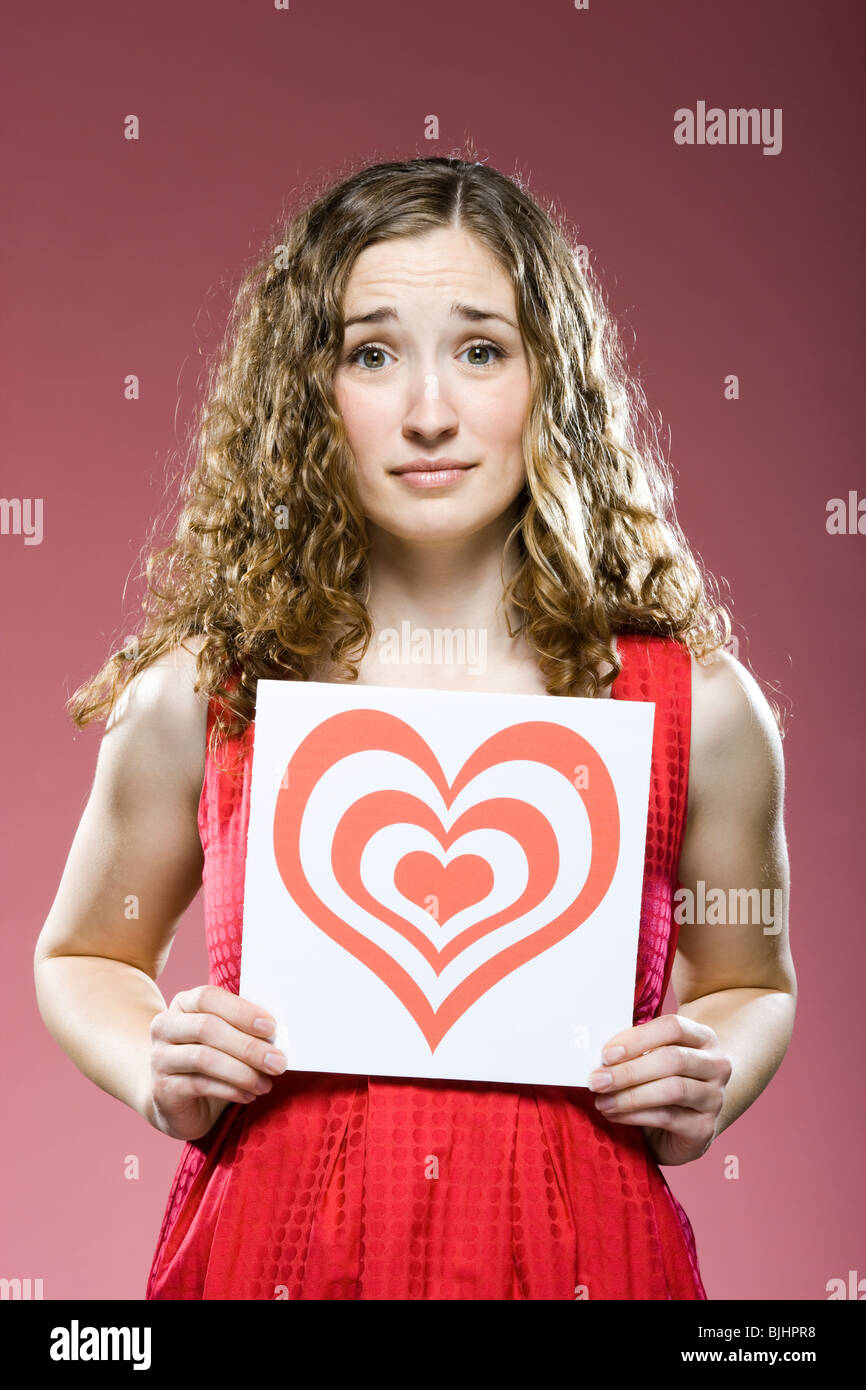 woman holding a red heart over her chest Stock Photo - Alamy