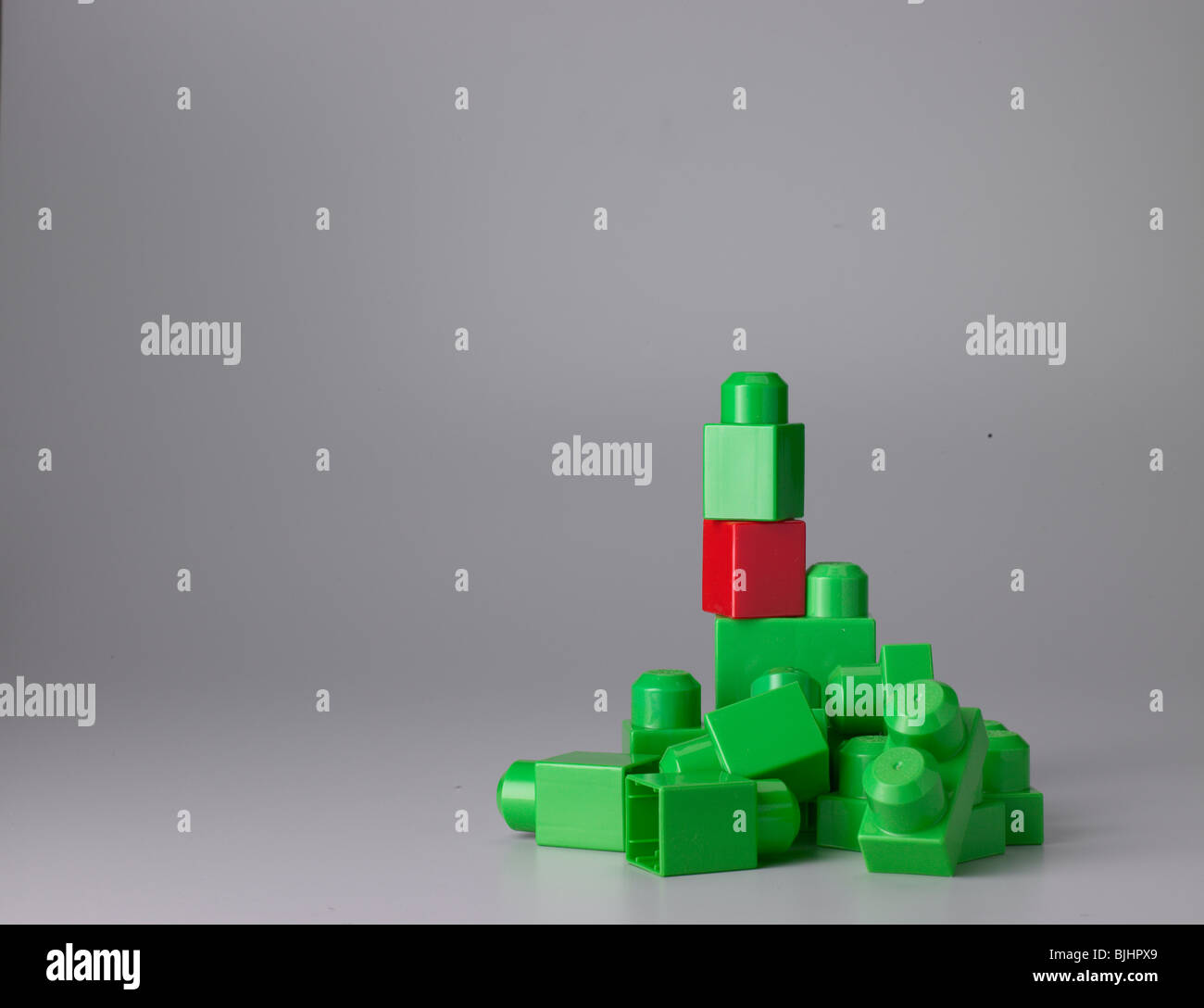 Green and red toy building blocks on grey showing formation and ...