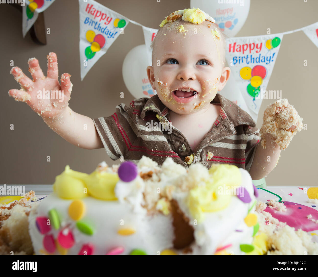 Baby covered in birthday cake Stock Photo - Alamy