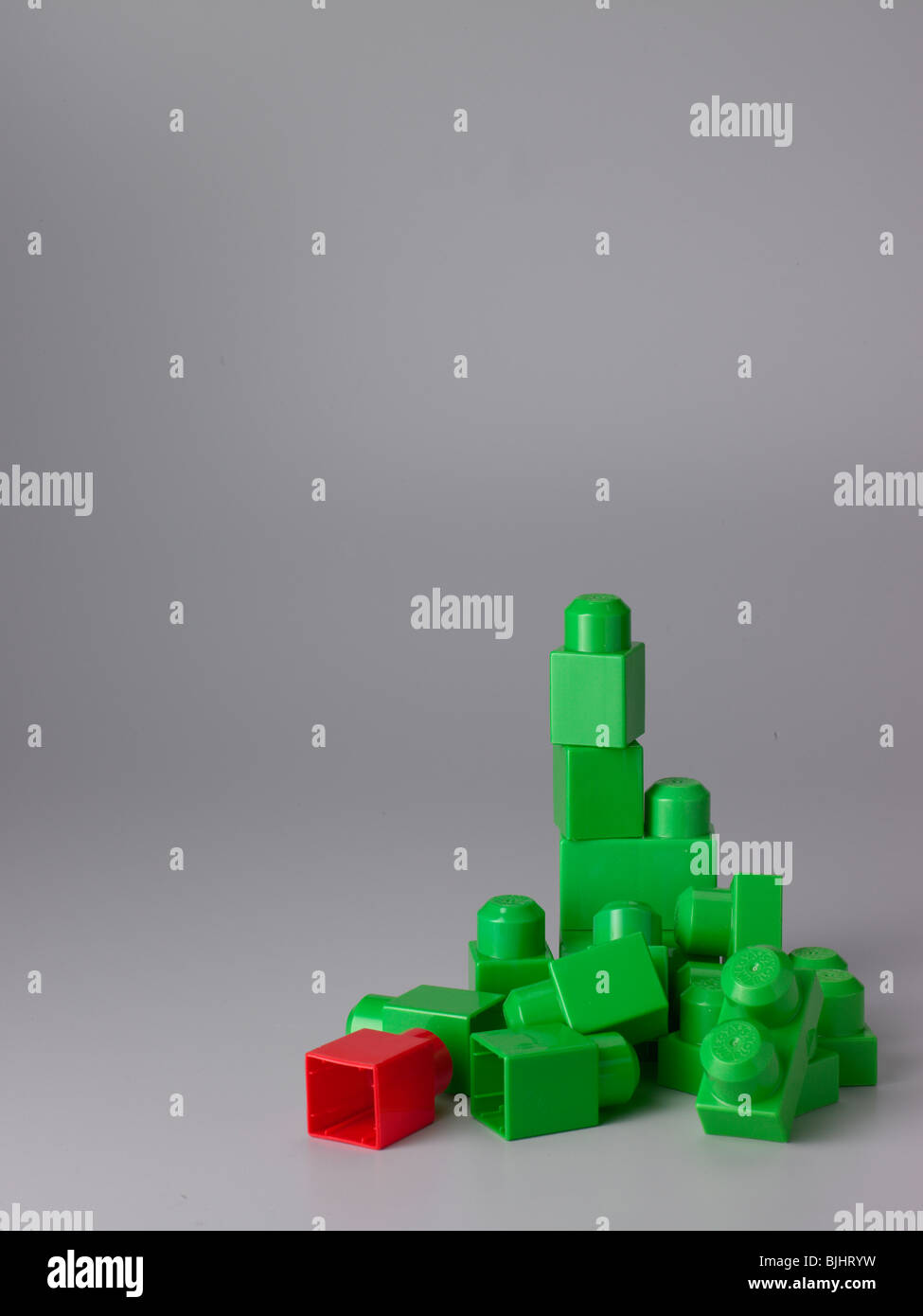 Green and red toy building blocks on grey showing formation and ...
