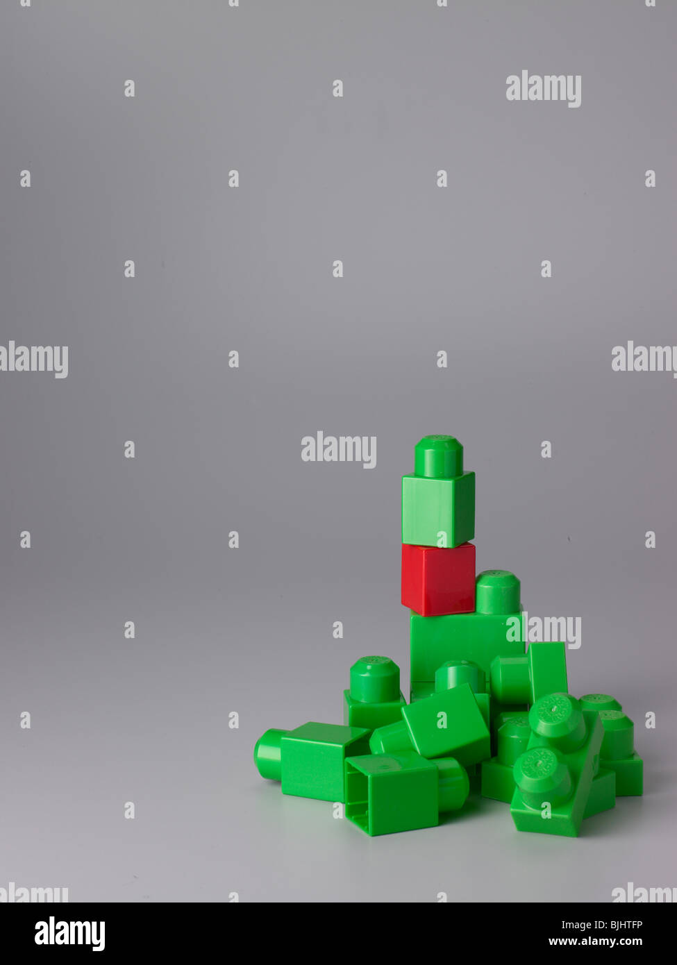Green and red toy building blocks on grey showing formation and ...