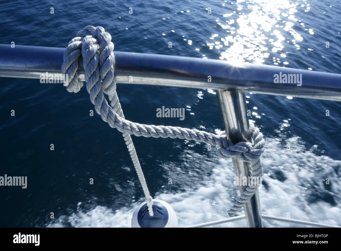 Nautical marine fender knot around stainless steel lee on blue ocean ...