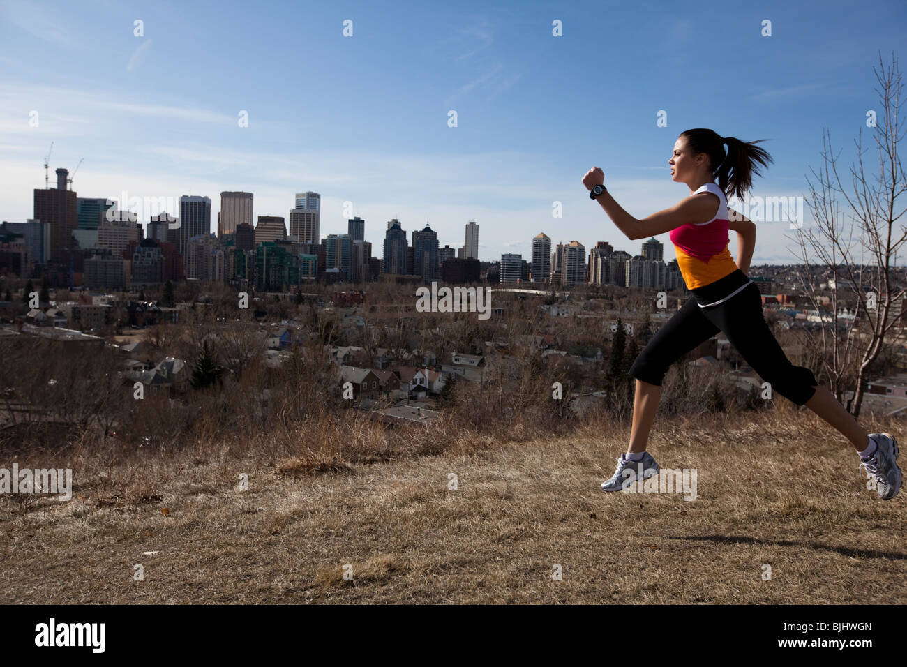 Fit young woman running with Calgary city skyline in background Stock ...
