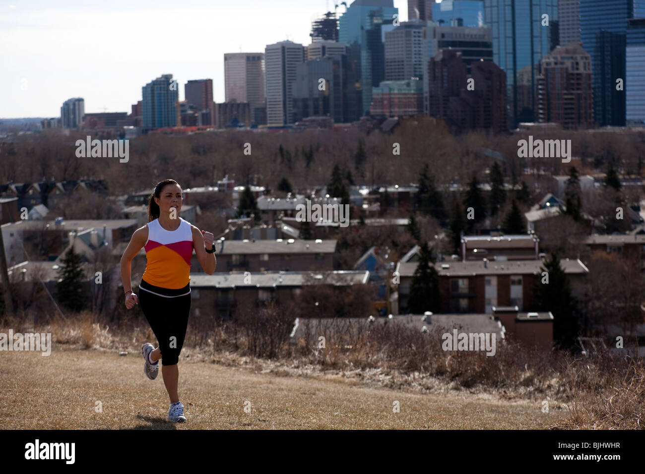 Fit young woman running with Calgary city skyline in background Stock ...