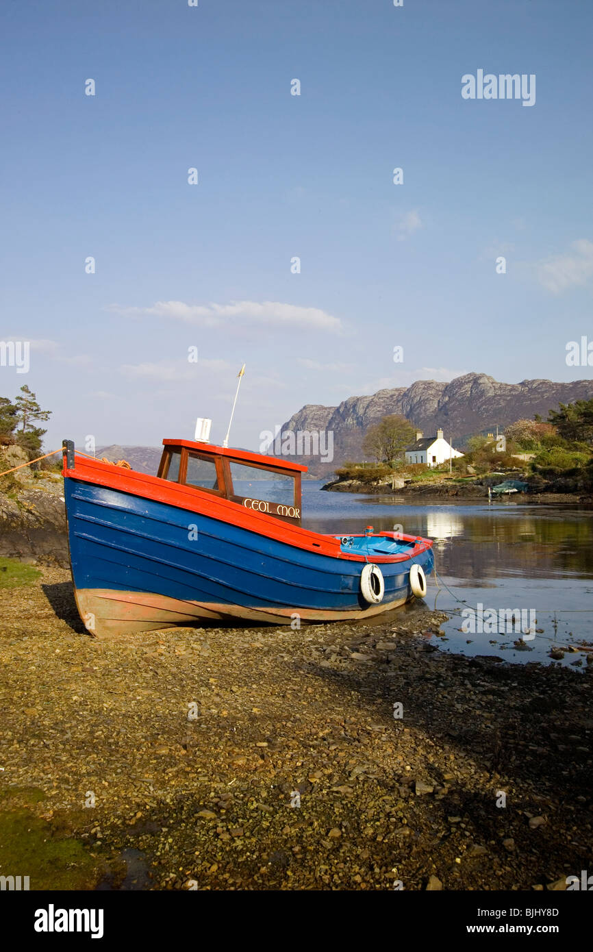 Colourful clinker-built sea going launch moored at high tide in small ...