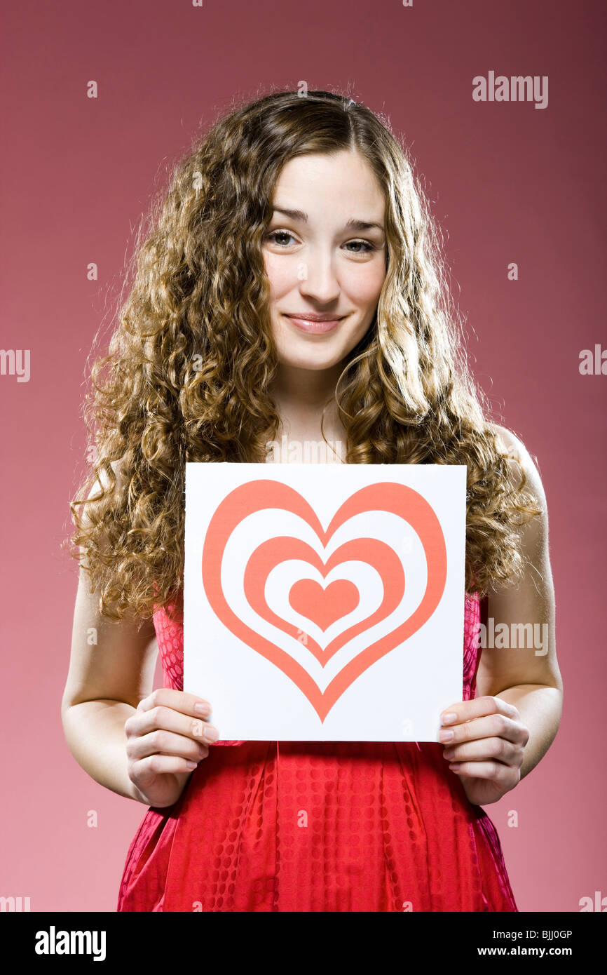woman holding a red heart over her chest Stock Photo - Alamy