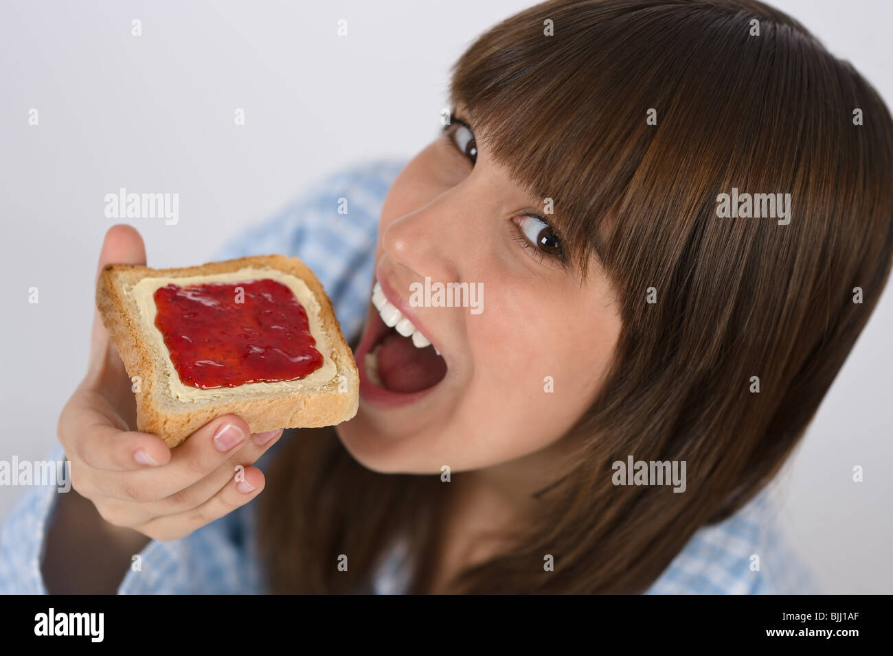 Happy teenager in pajamas eating healthy toast for breakfast Stock ...