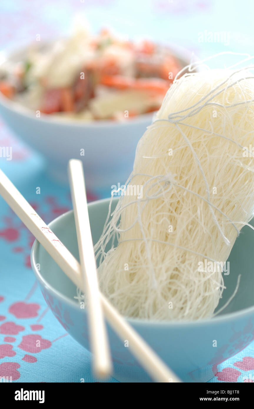 Raw chinese rice noodles on blue background Stock Photo - Alamy
