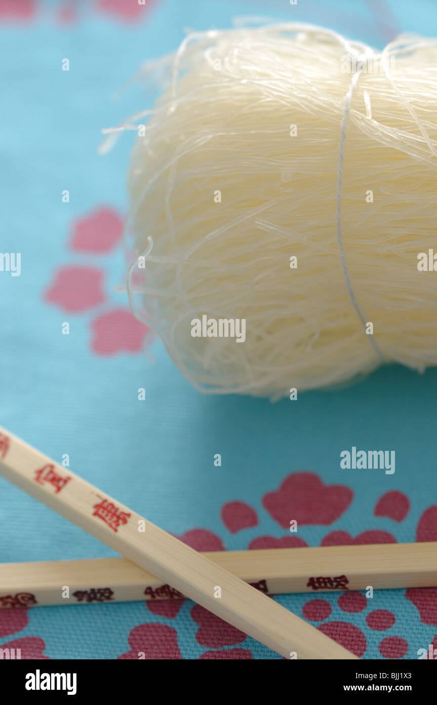 Raw chinese rice noodles on blue background Stock Photo - Alamy