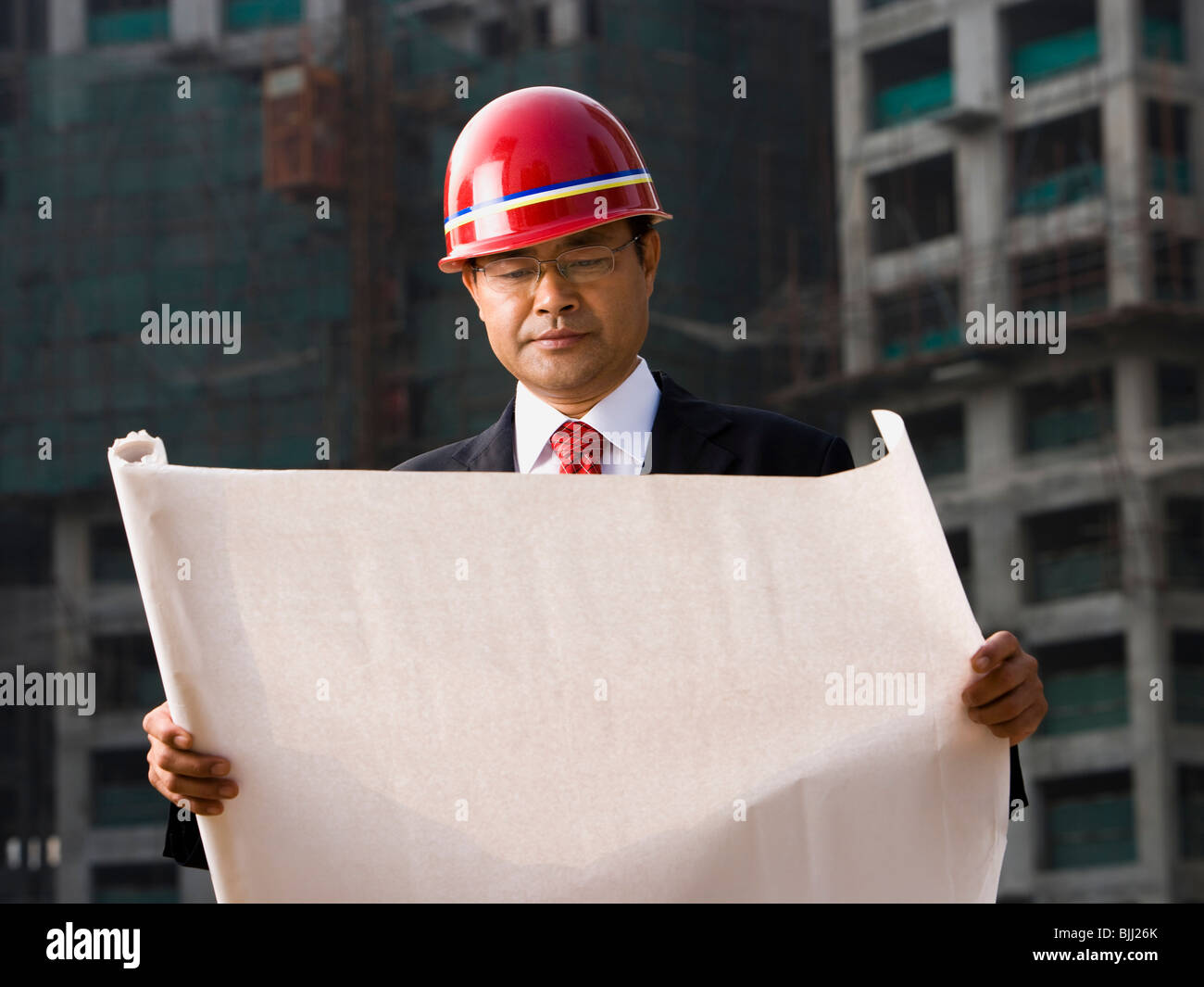 Construction site foreman with blueprints outdoors Stock Photo - Alamy