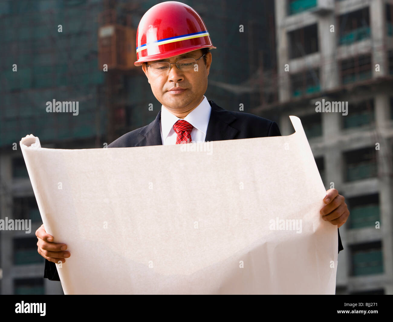 Construction site foreman with blueprints outdoors Stock Photo - Alamy