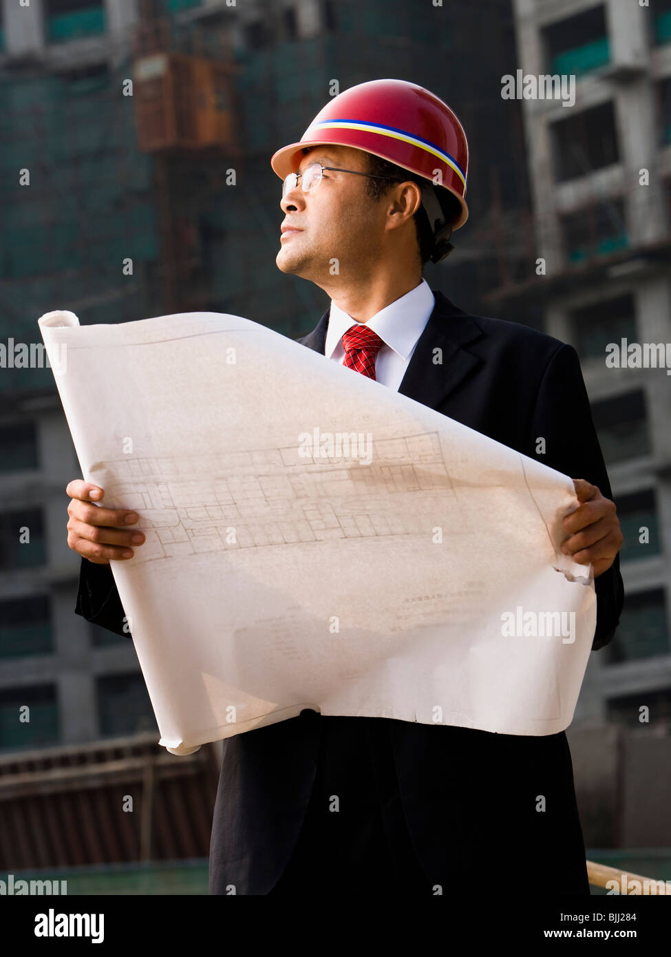 Construction site foreman with blueprints outdoors Stock Photo - Alamy