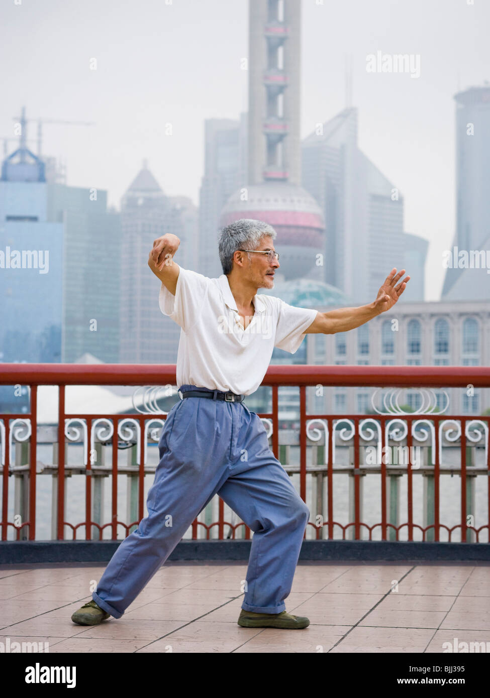 Man doing tai chi outdoors with city skyline in background Stock Photo ...