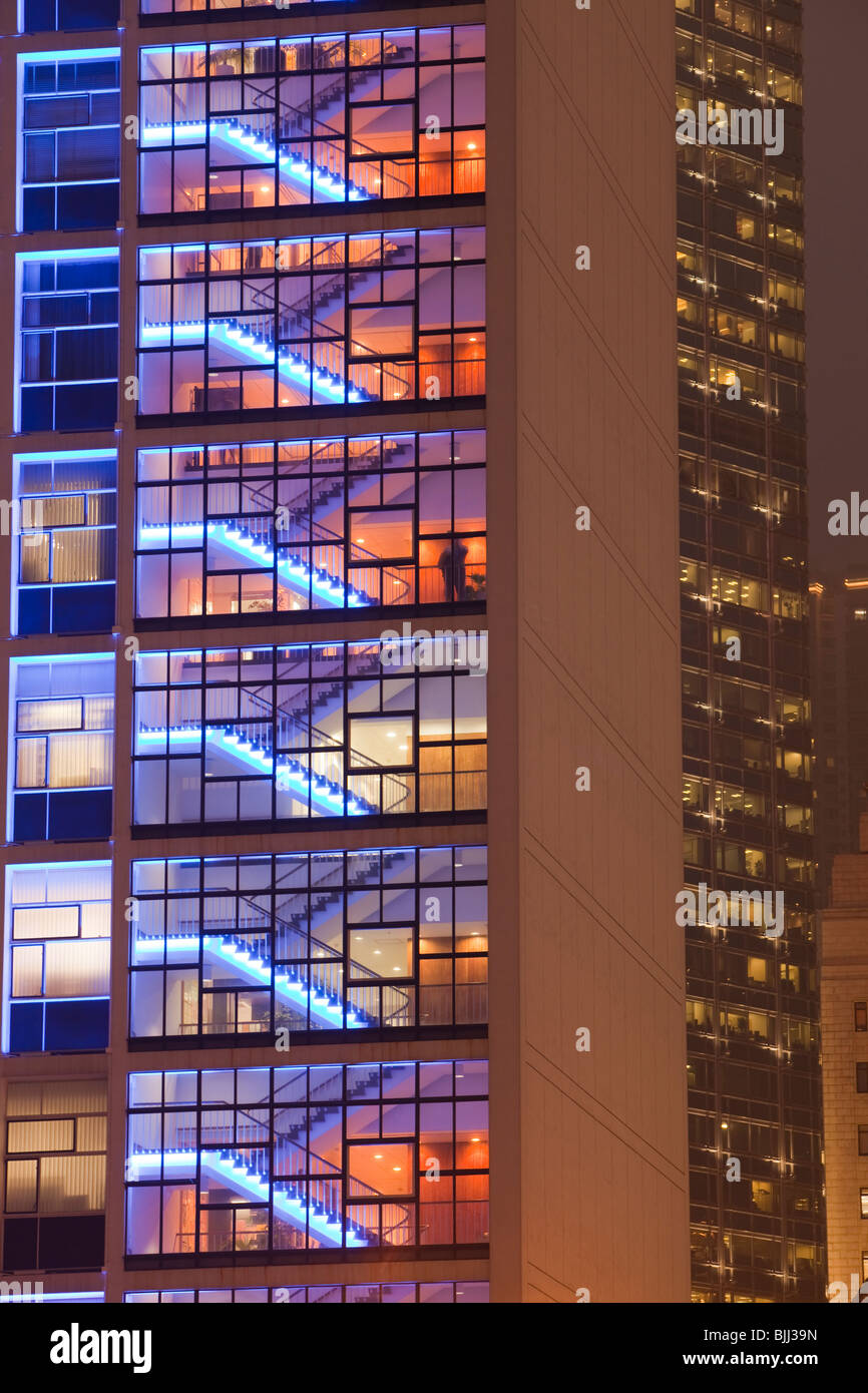Office blocks lit up at night in Hong Kong, China. This densely ...