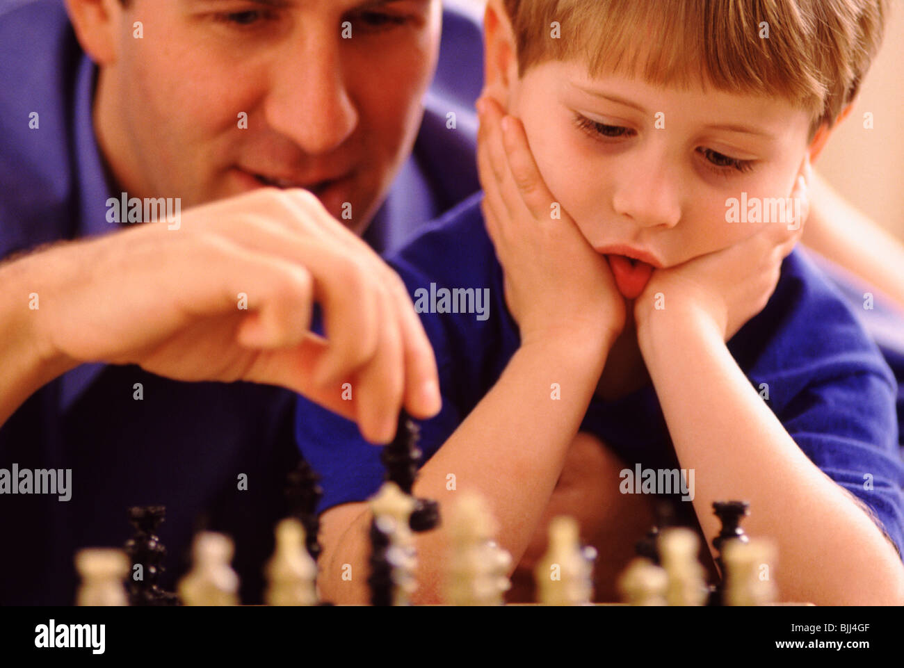 Father and son playing chess Stock Photo - Alamy