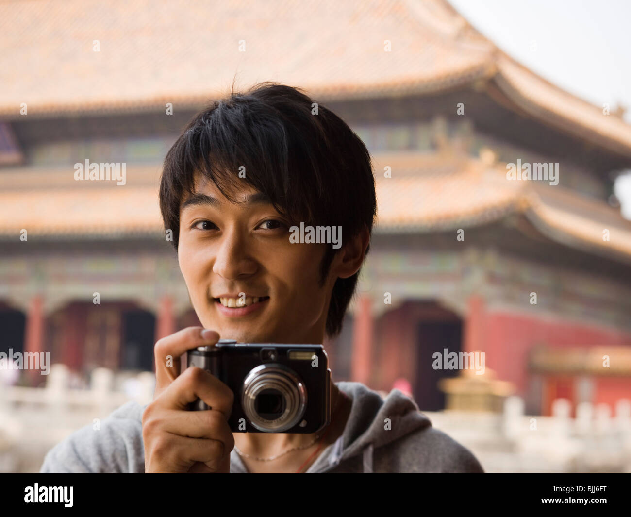 Teenage boy outdoors with digital camera smiling Stock Photo - Alamy
