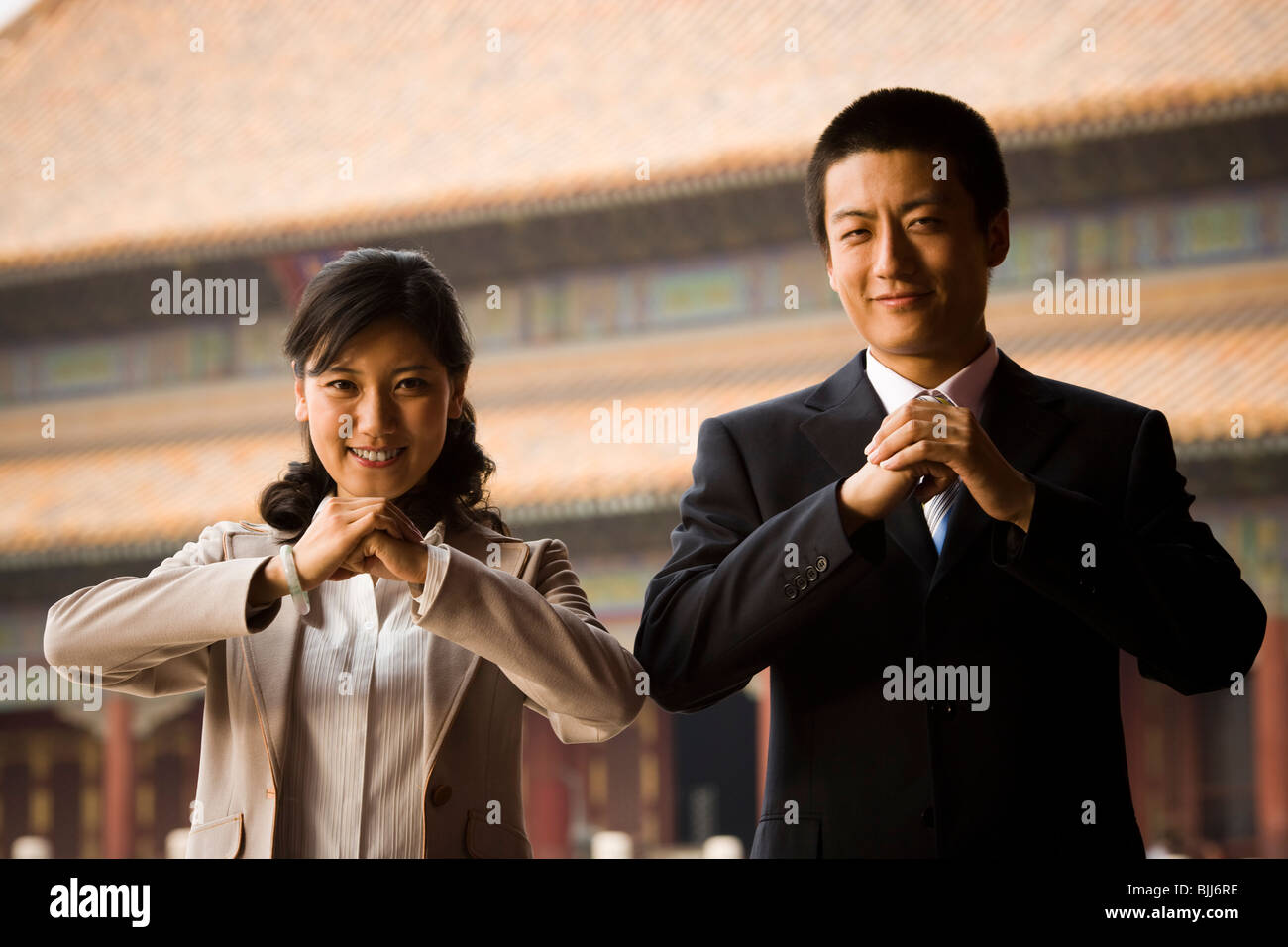 Businesswoman and man doing tai chi outdoors smiling Stock Photo - Alamy