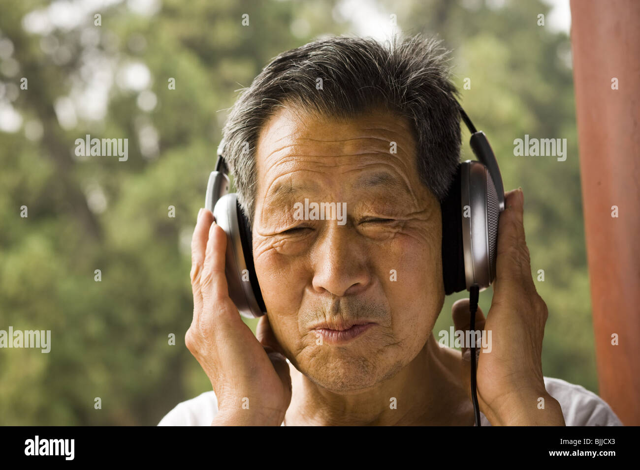 Toothless man with headphones outdoors smiling Stock Photo - Alamy