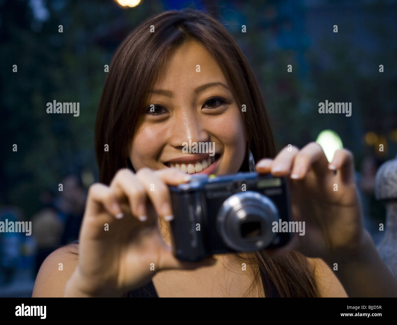Woman taking a photograph smiling Stock Photo - Alamy