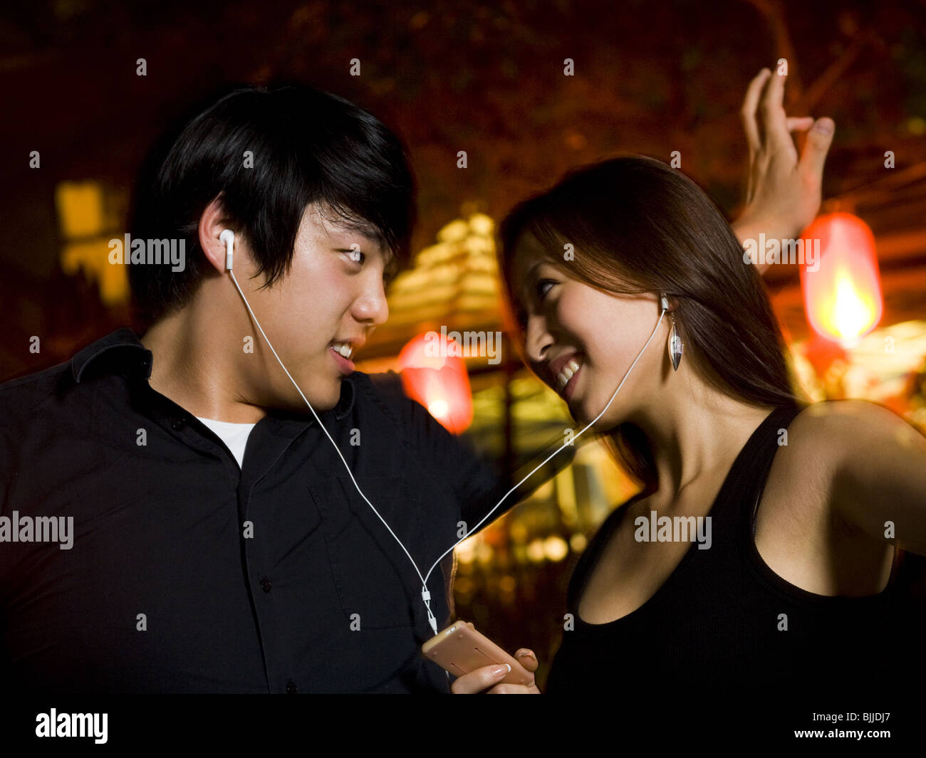 Couple listening to mp3 player outdoors dancing and smiling Stock Photo ...