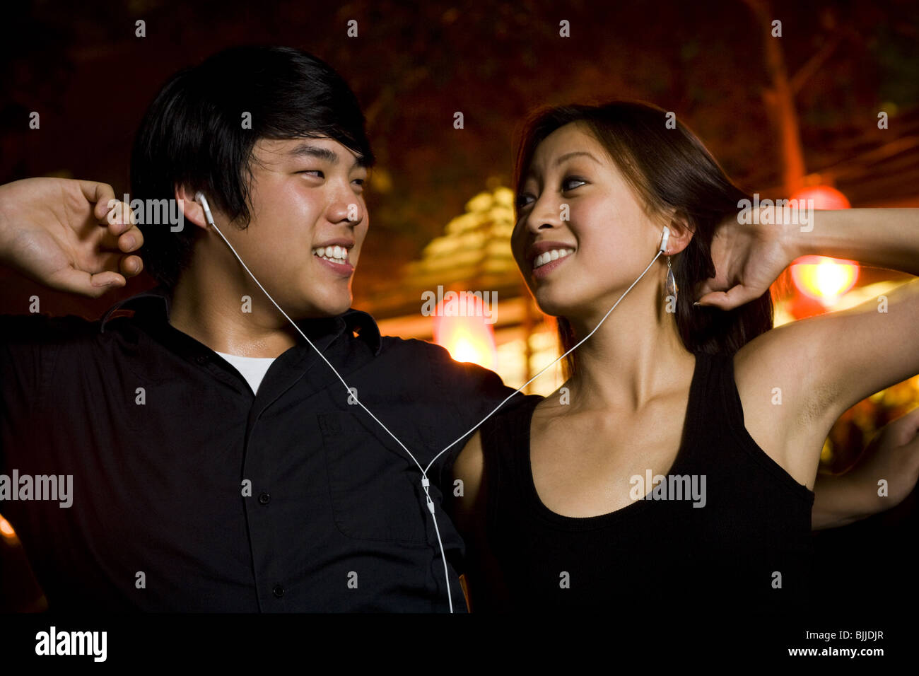 Couple listening to mp3 player outdoors dancing and smiling Stock Photo ...