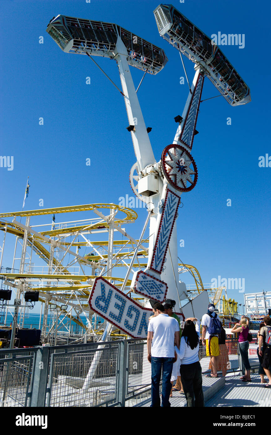 England, East Sussex, Brighton, People watching the pendulum ride on ...
