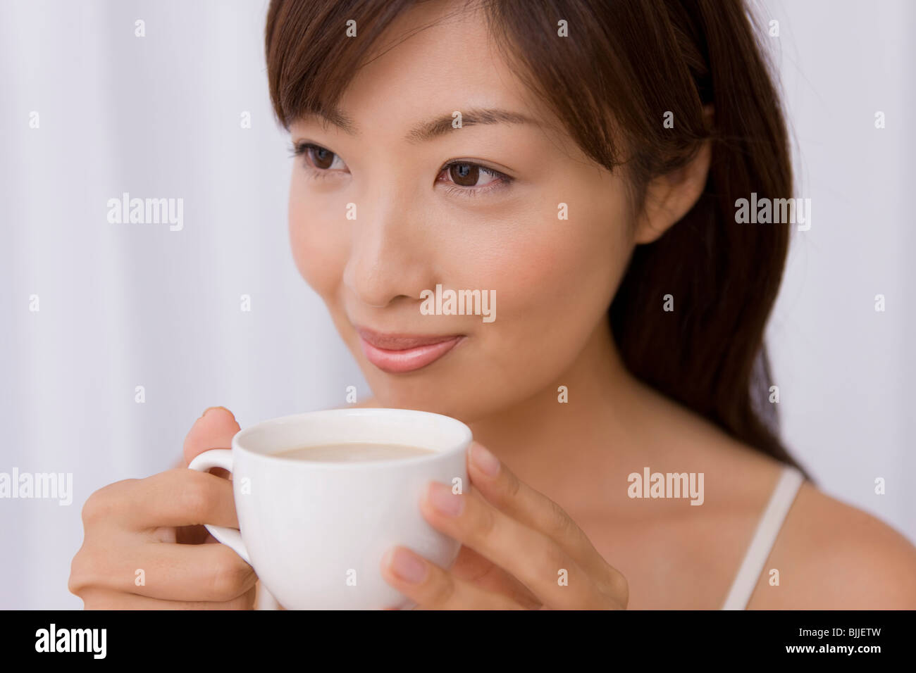 Young woman drinking coffee Stock Photo - Alamy