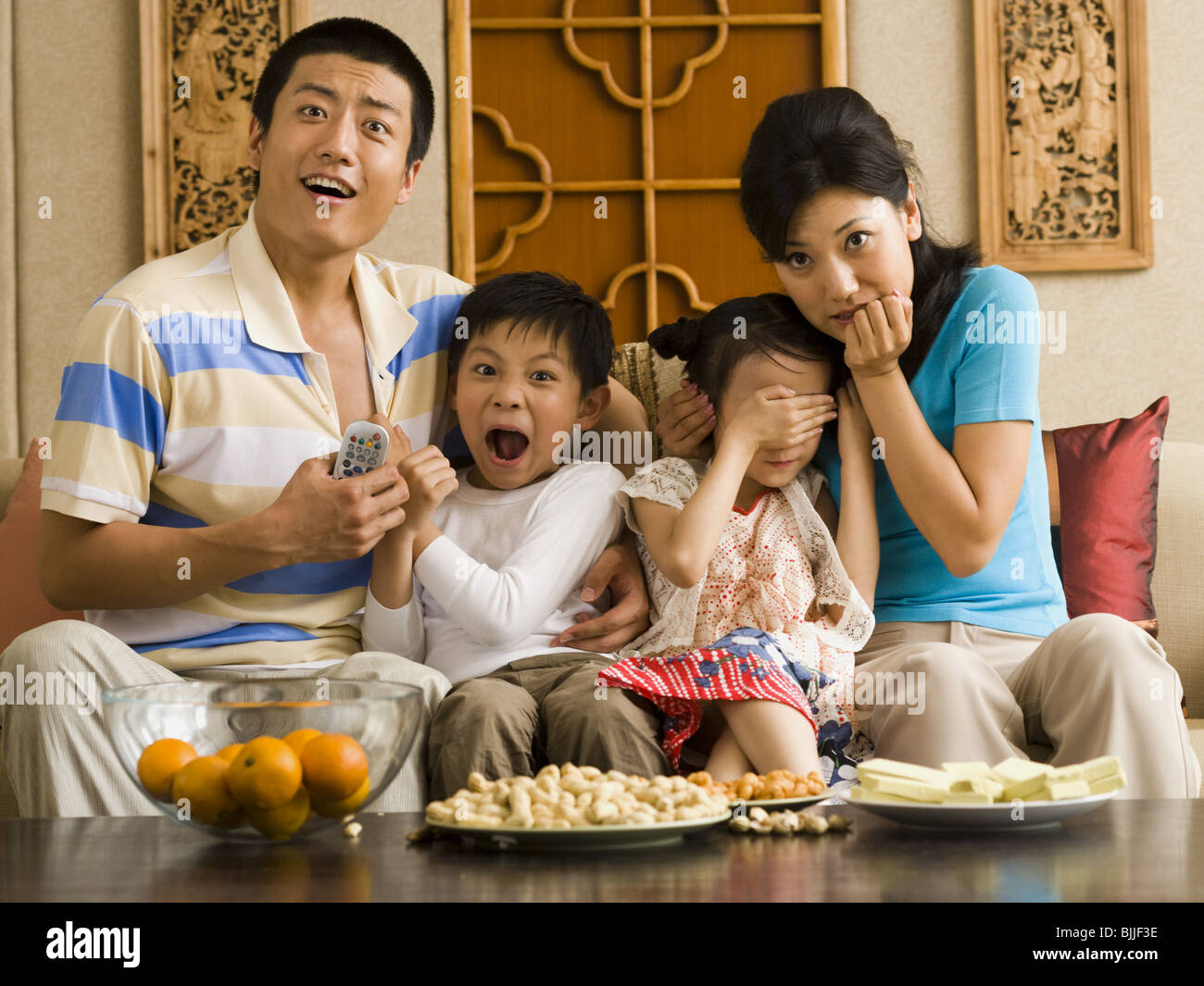 Shocked family watching television Stock Photo - Alamy