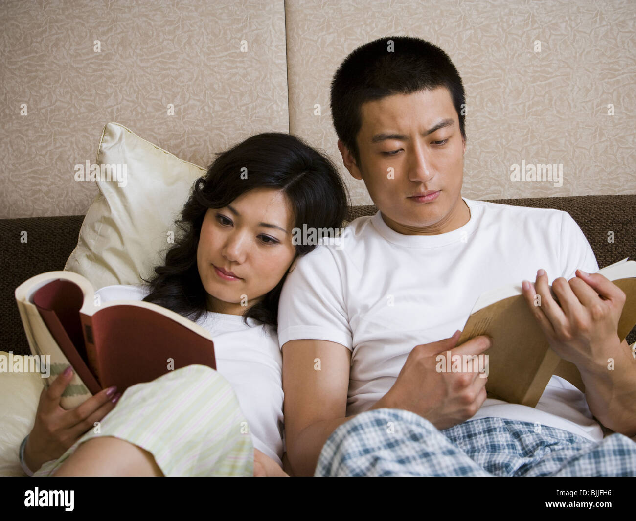 Couple in bed snuggling reading hi-res stock photography and images - Alamy