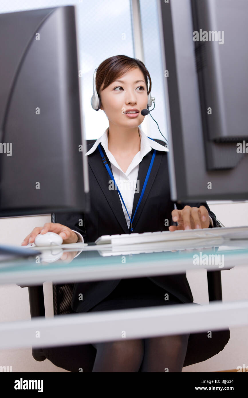 Young woman working in front of computer Stock Photo - Alamy