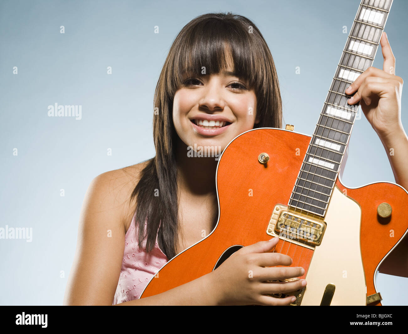 Woman playing guitar smiling Stock Photo - Alamy
