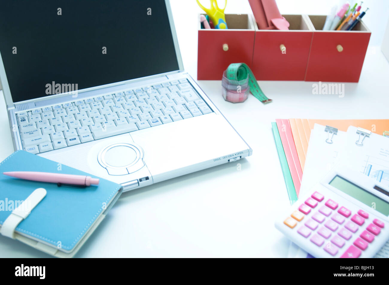 Calculator laptop and files on desk Stock Photo - Alamy