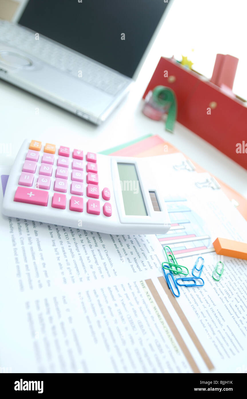 Calculator laptop and files on desk Stock Photo - Alamy