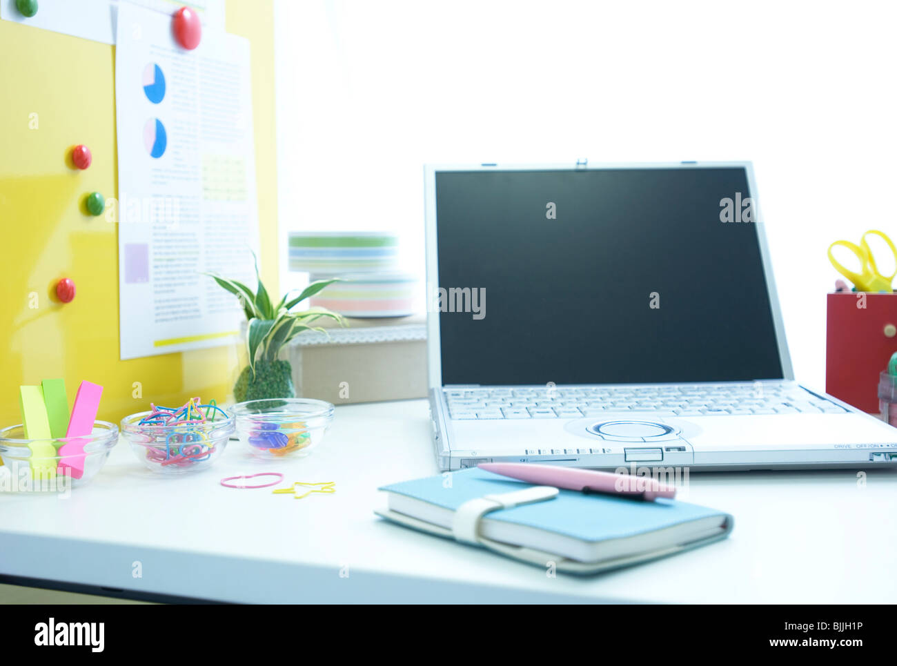 Laptop and notebook on desk Stock Photo - Alamy