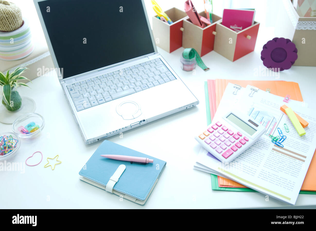 Calculator files and laptop on desk Stock Photo - Alamy