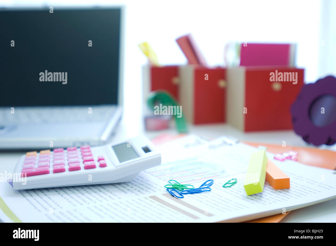 Calculator files and laptop on desk Stock Photo - Alamy