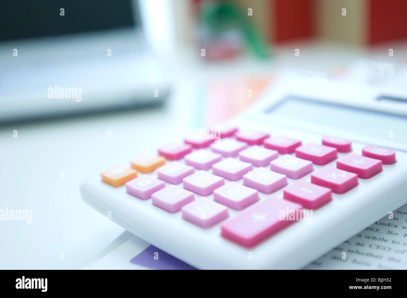 Pink calculator on desk with laptop Stock Photo - Alamy