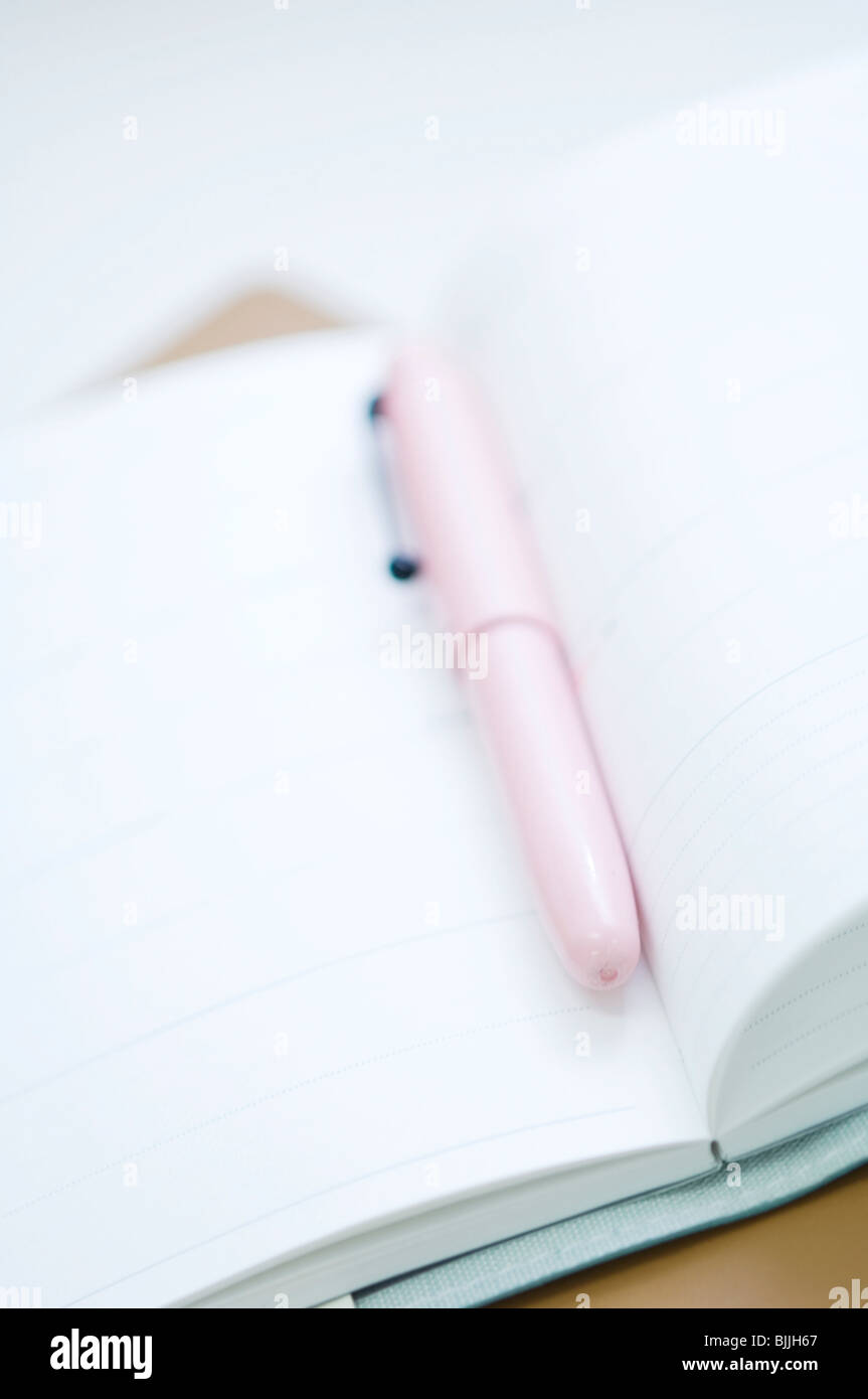 Open notebook and a pen Stock Photo - Alamy