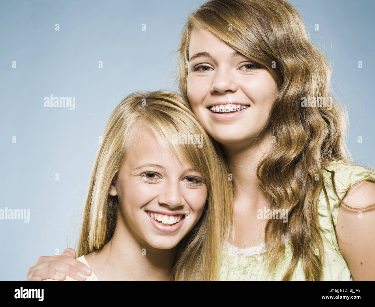 Two girls embracing and smiling Stock Photo - Alamy