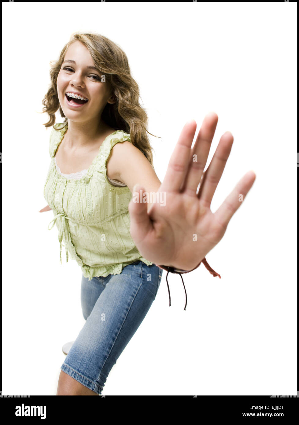 Girl with braces dancing and smiling with arms up Stock Photo - Alamy