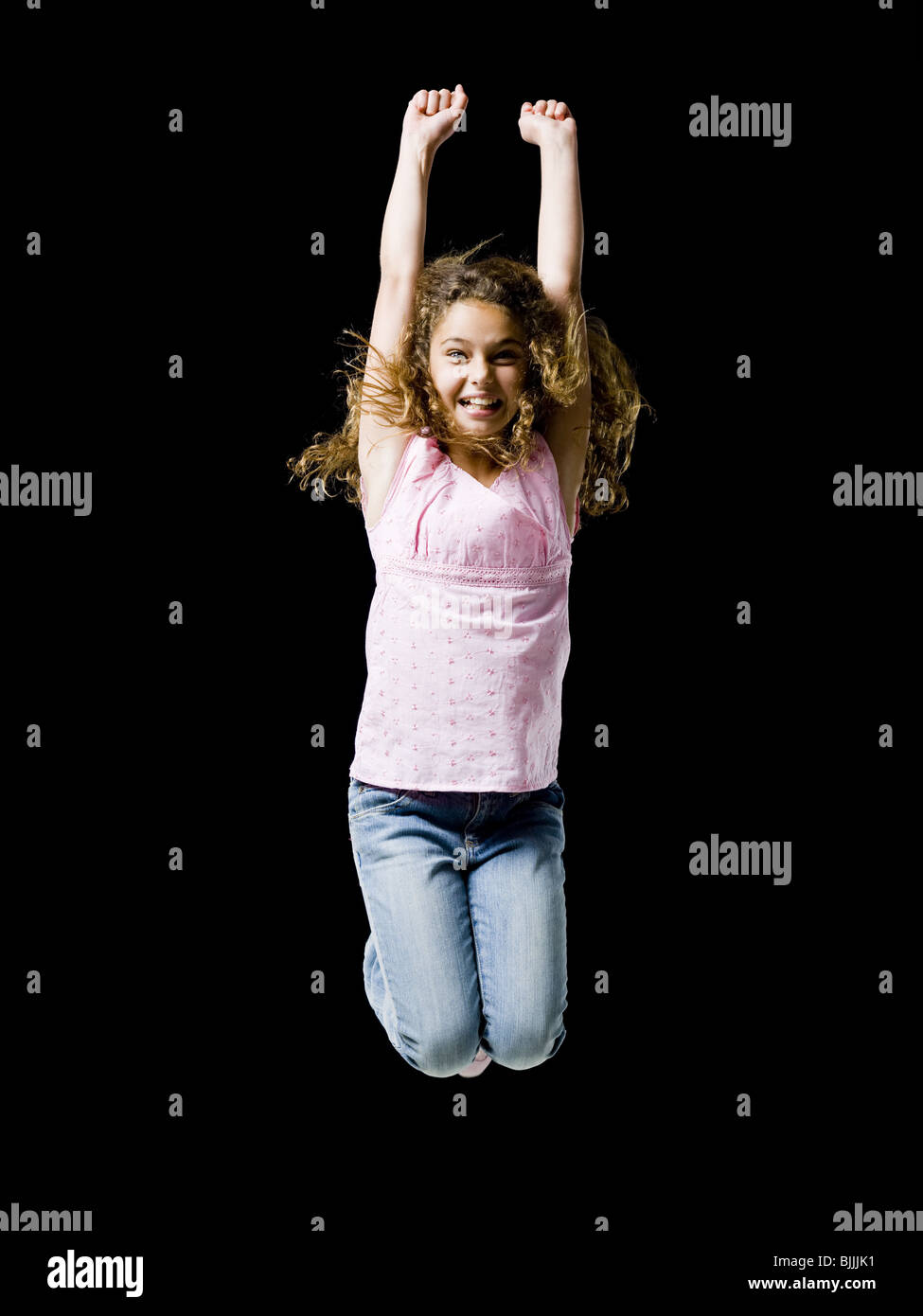 Girl leaping and smiling with arms up Stock Photo - Alamy